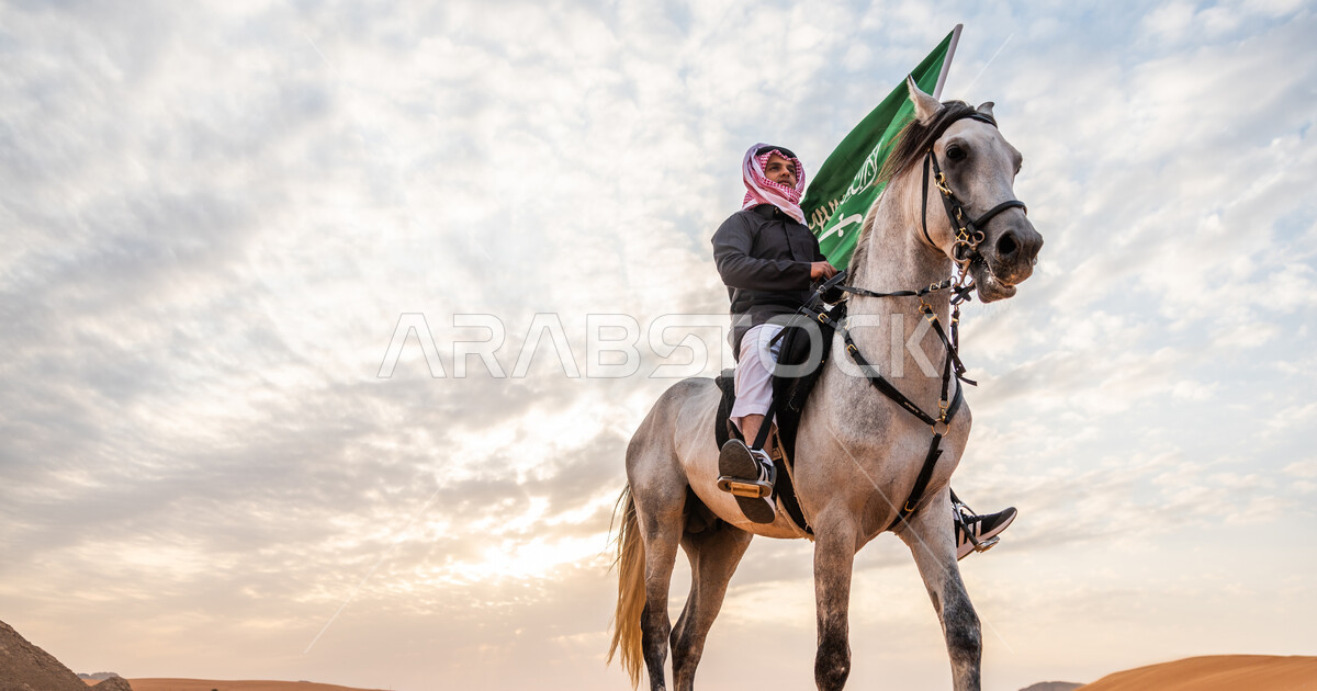 A Saudi Gulf rider riding a horse in the picturesque desert of Saudi ...