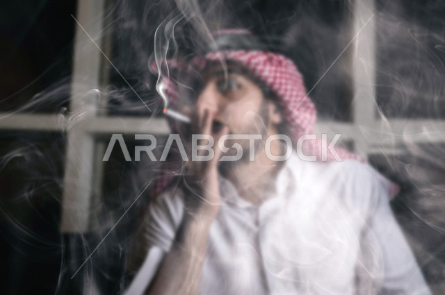 A Saudi Arabian Gulf youth smokes cigarettes, takes harmful and toxic ...