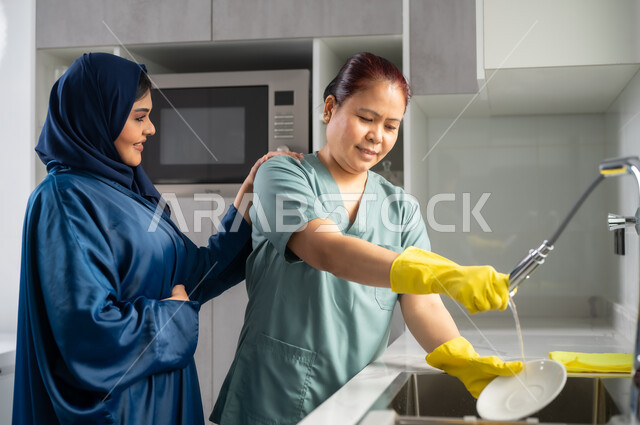 Disinfection, cleaning, and washing dishes. A Saudi Arabian Gulf woman ...