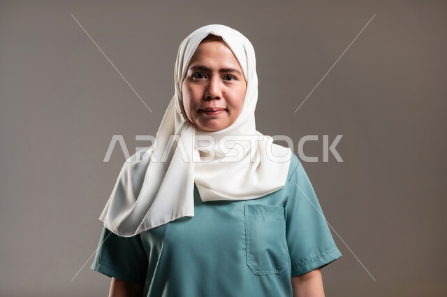 Wearing uniforms for Saudi domestic workers, standing in a ready position, close-up portrait of ...
