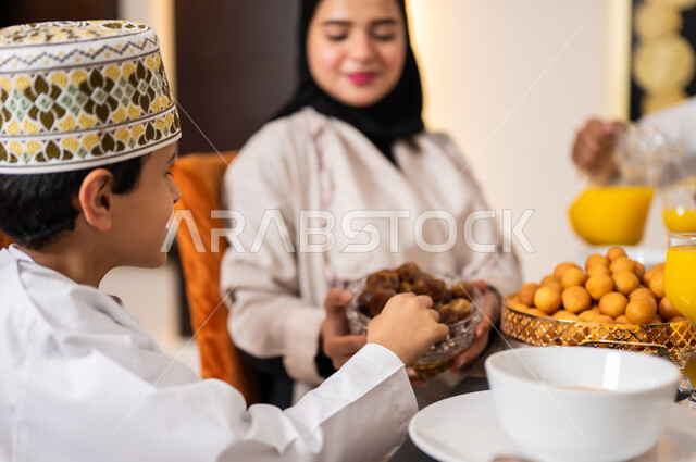 Preparing the Iftar meal, the family gathering around the dining table ...
