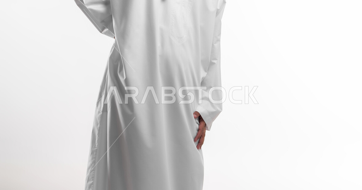 Feeling pain in the spine, portrait of an Arab Gulf Omani man wearing a ...