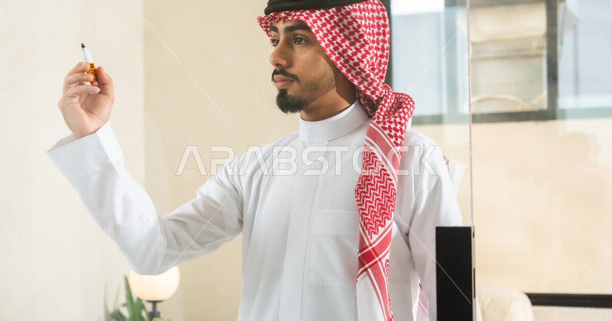 Preparing to write and write down something, a smiling Saudi Gulf Arab ...