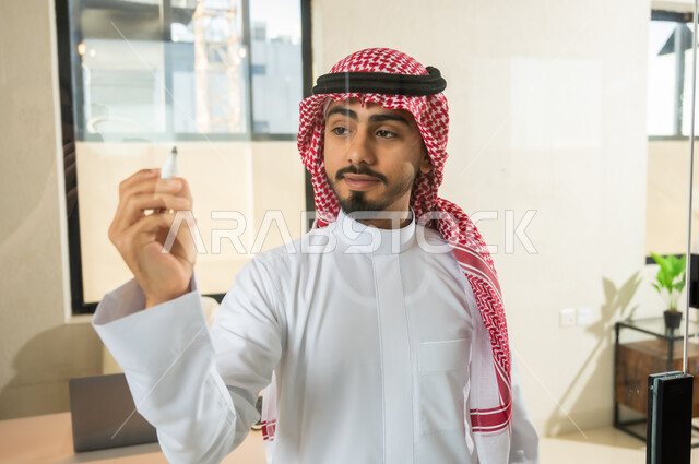Preparing to write and write down something, a smiling Saudi Gulf Arab ...