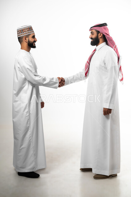 Handshake and return greeting, portrait of two young Arab men, a Saudi ...