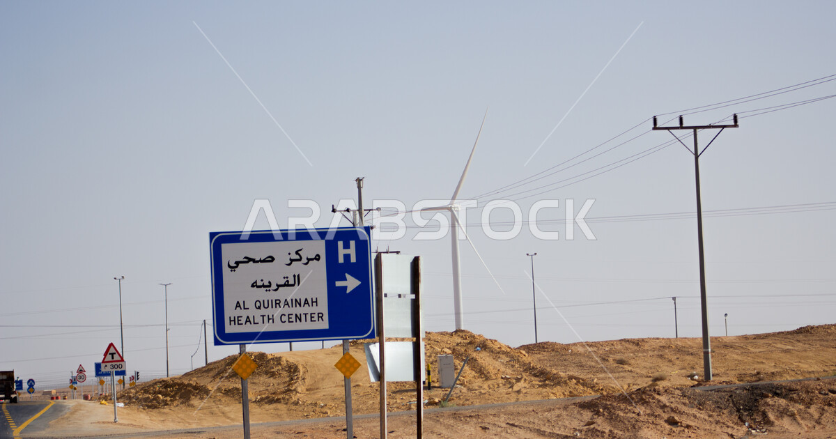 A blue signboard for the Qurayna Health Center, phrases and texts in ...