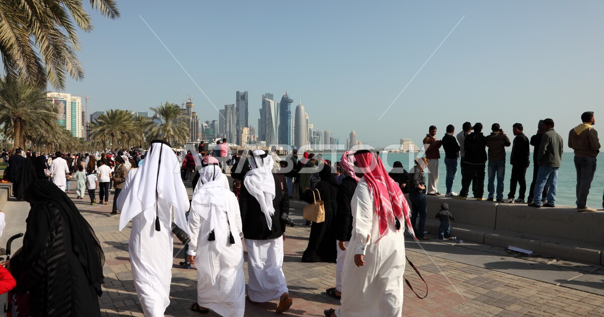 A group of Gulf Arab tourists wandering around natural areas, gardens ...