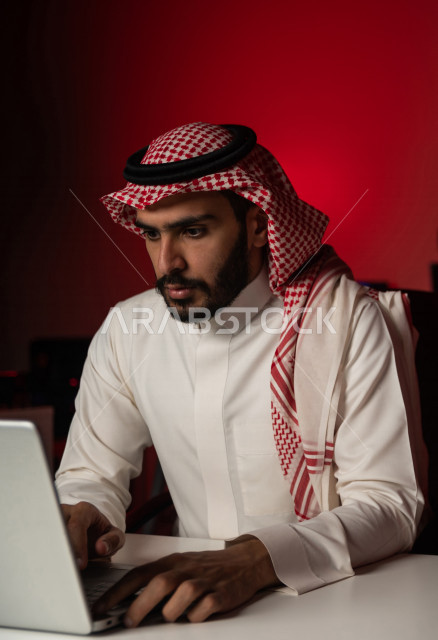 A Saudi Arabian Gulf businessman using a laptop computer, remote work ...