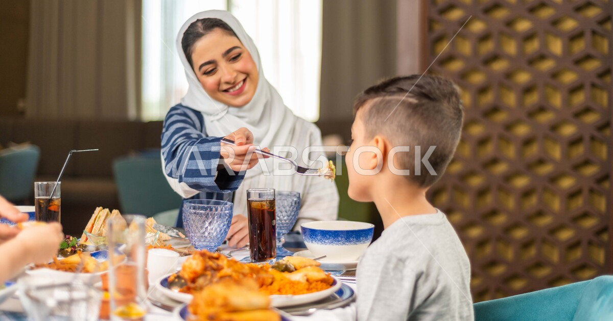 A Saudi Arabian Gulf family sitting in the restaurant, a smiling and ...