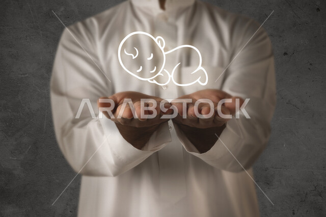 صورة مقربة ليد رجل عربي خليجي سعودي ، يحمل بين يديه بيبي صغير بتقنية ...