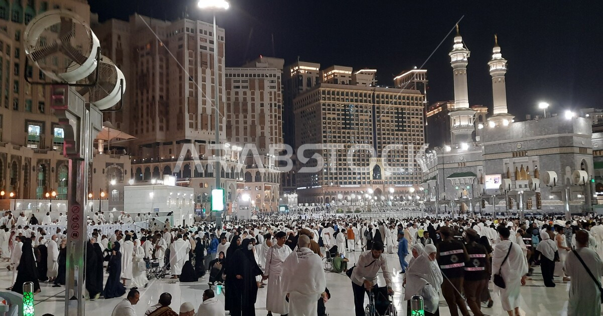A group of pilgrims in the Grand Mosque in Mecca at night, performing ...