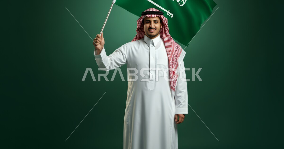 Portrait of a Saudi Gulf Arab man holding the flag of the Kingdom of ...