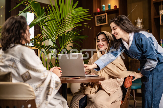 Saudi Arabian Gulf girls using a laptop computer, business women ...