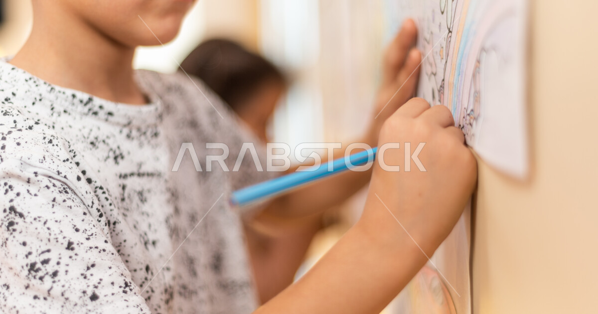 A close-up photo of a Saudi Arabian Gulf child who is actively creative ...