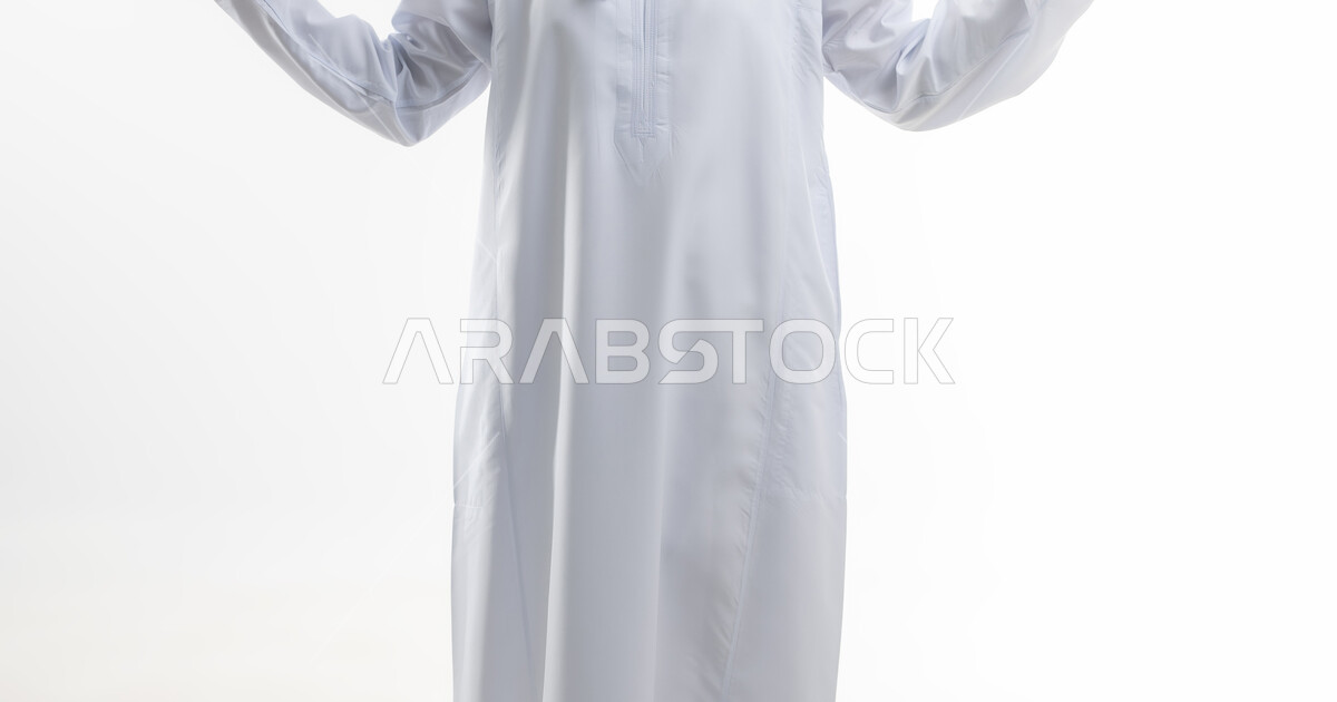 Portrait of a young Arab Gulf Omani man wearing a dishdasha and a ...