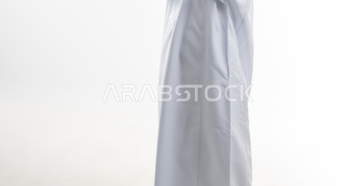 Portrait of a young Arab Gulf Omani man wearing a dishdasha and a ...
