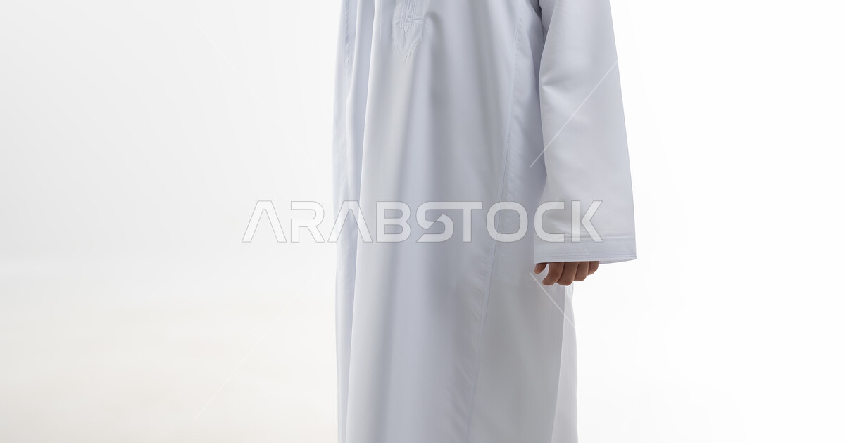 Portrait of a young Arab Gulf Omani man wearing a dishdasha and a ...