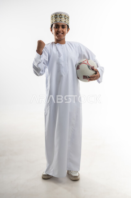 Portrait of a young Arab Gulf Omani man wearing a dishdasha and a ...