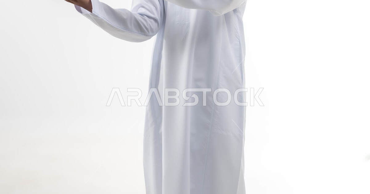 Portrait of a young Arab Gulf Omani man wearing a dishdasha and a ...