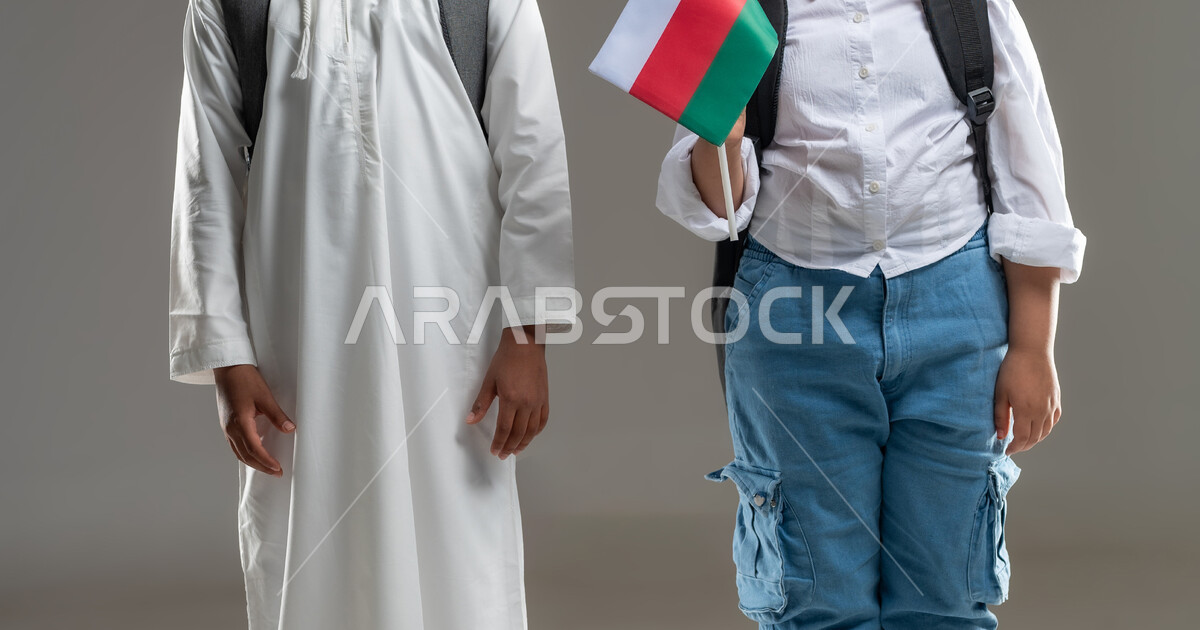 Portrait of a boy wearing a dishdasha and Omani kummah and a girl ...
