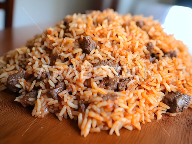 A meal of Kabsa rice with spices and meat on a wooden table ...