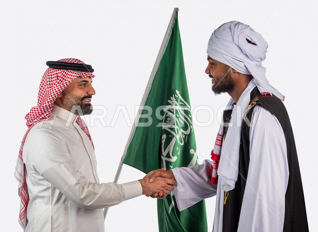 Portrait of a Saudi Arabian Gulf man in Saudi traditional dress shaking ...