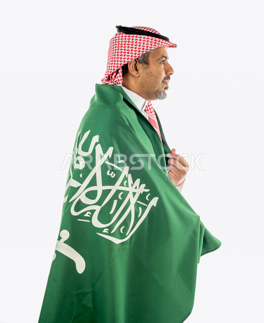 Portrait of a Saudi Arabian Gulf man putting on his back the flag of ...