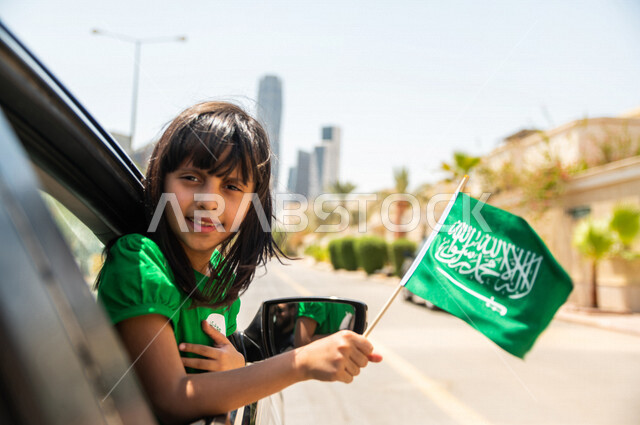 A Saudi Arabian Gulf girl waving the flag of the Kingdom of Saudi ...