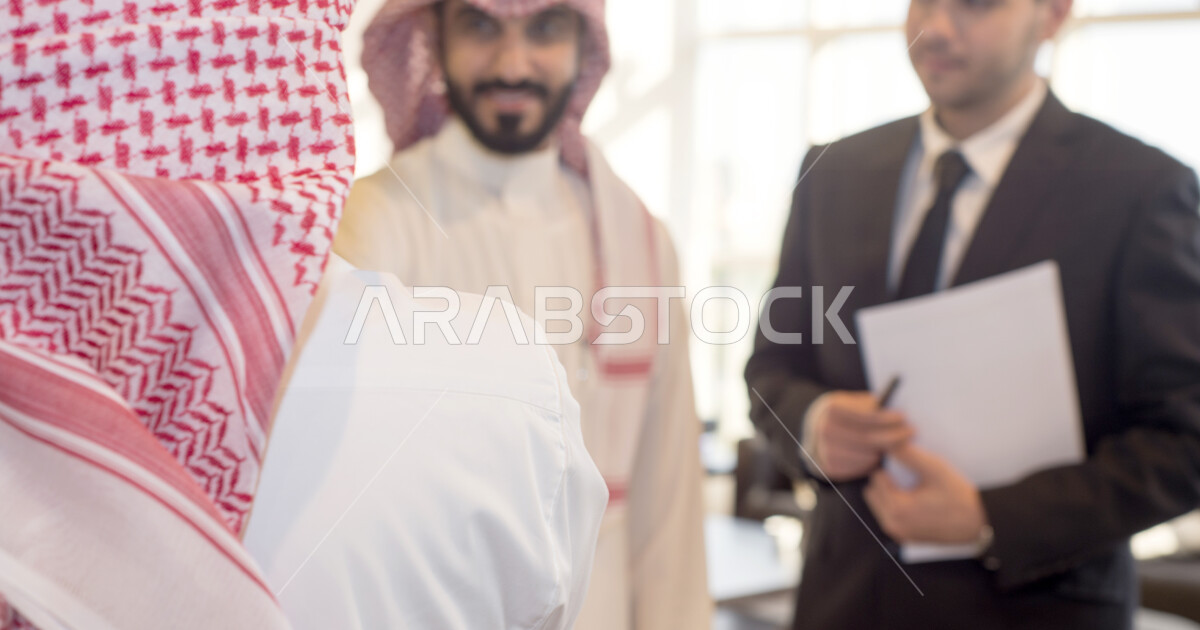 Saudi Arabian Gulf business team Two Saudi Arab men shake hands after ...