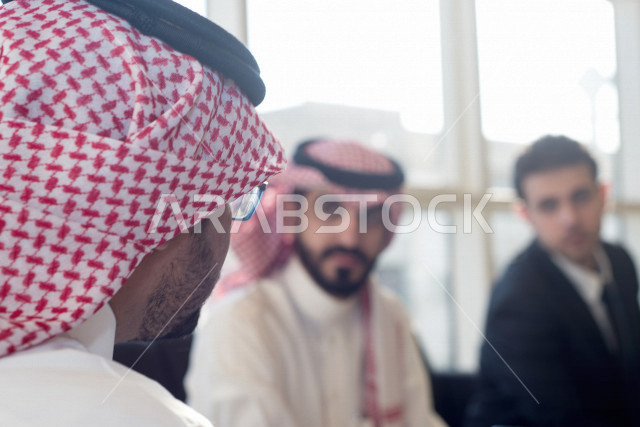 Saudi Arabian Gulf business team Two Saudi Arab men shake hands after ...