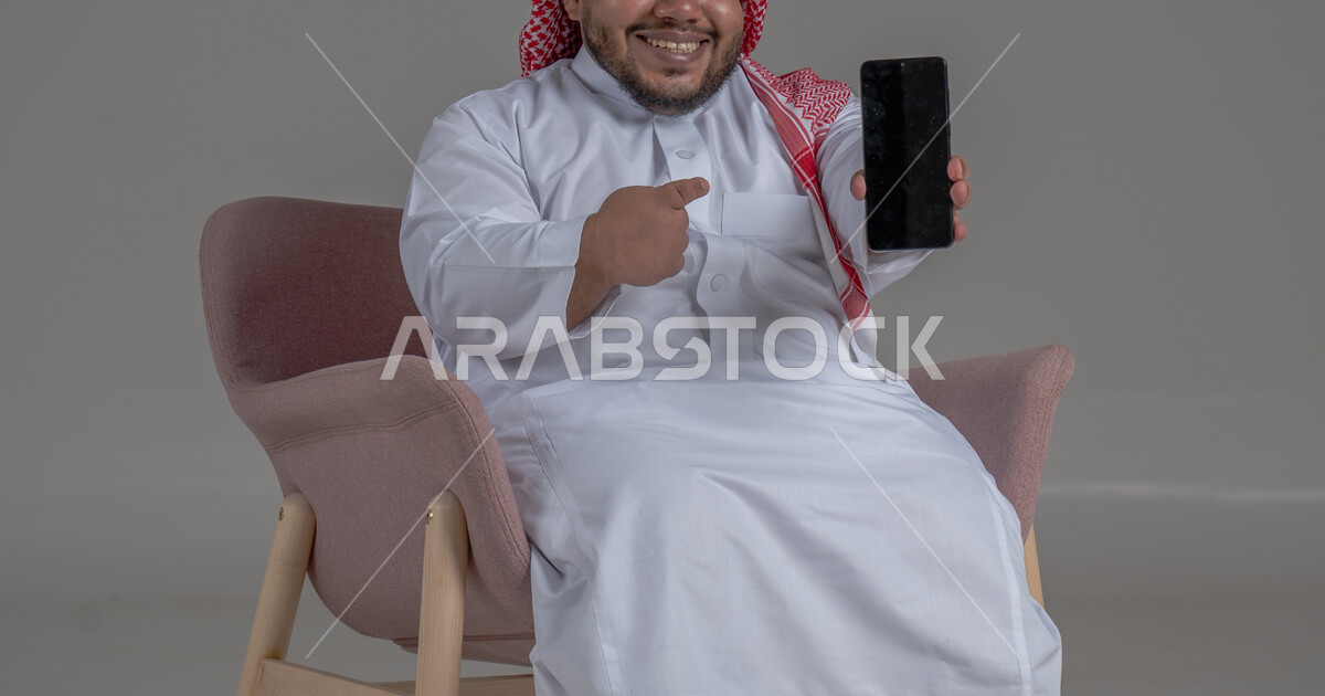 Having a good time, portrait of a short Saudi Arabian Gulf man sitting ...