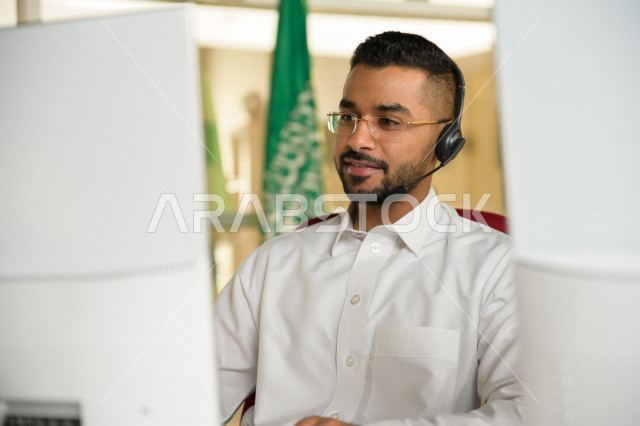 A Saudi Arabian Gulf employee working in customer service and wearing a ...
