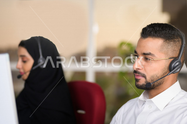 Two Saudi Arabian Gulf employees working in customer service, an ...