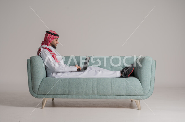 Using laptop to complete tasks, portrait of a Saudi Arabian Gulf man ...