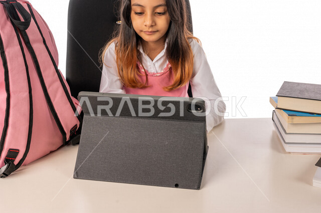 A Saudi Arabian Gulf schoolgirl wearing a school uniform, using a ...