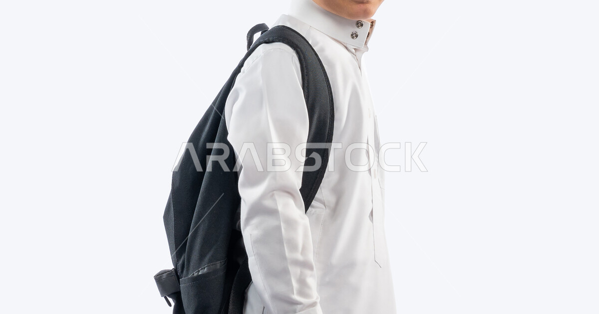 Portrait of a smiling Arab Gulf Saudi schoolboy, wearing a school ...