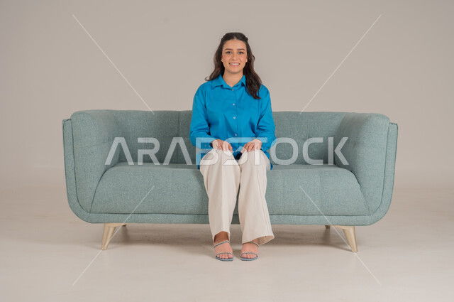 Sitting demurely and looking at the camera with gestures of happiness ...