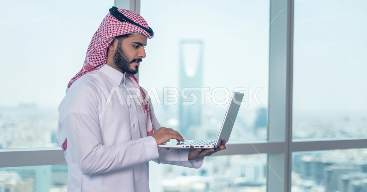A Saudi Arabian Gulf businessman uses a laptop computer, work remotely ...