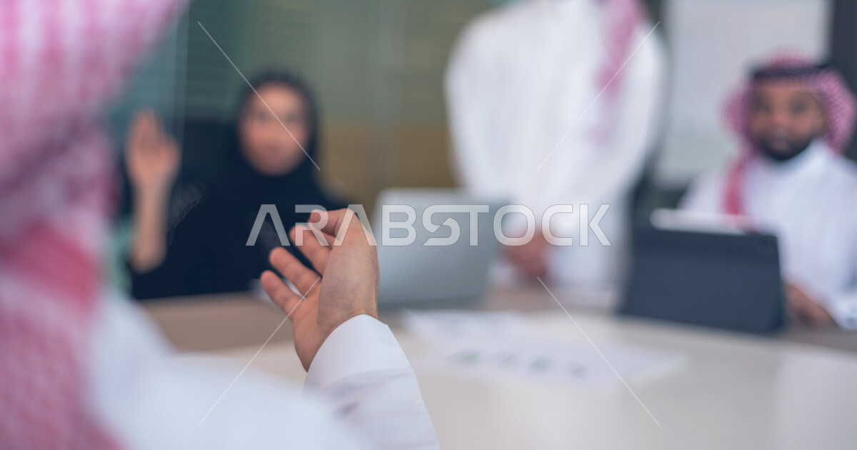 A group of businessmen and a businesswoman inside a Saudi company, a ...