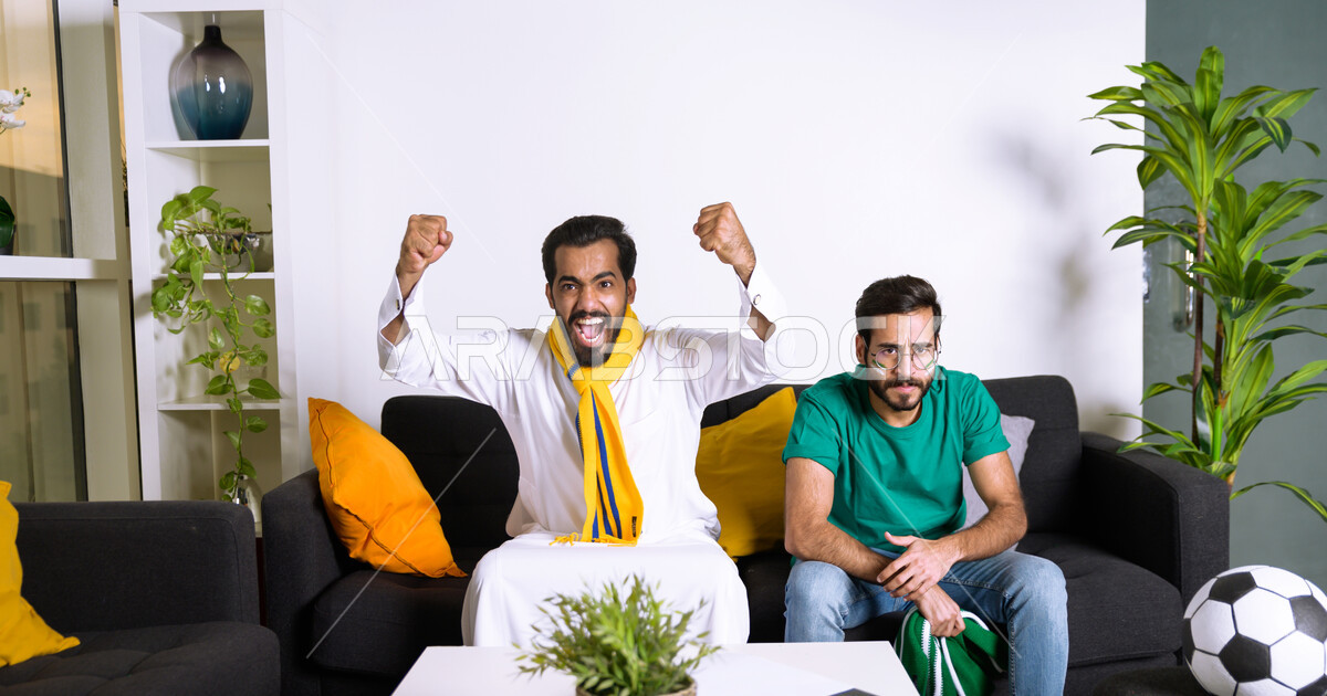 Two Saudi Arabian Gulf friends watching a Saudi league match, a young ...