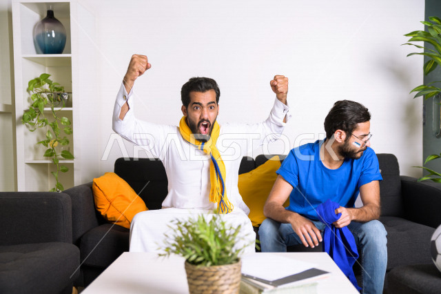 Two Saudi Arabian Gulf friends watching a Saudi league match, a young ...