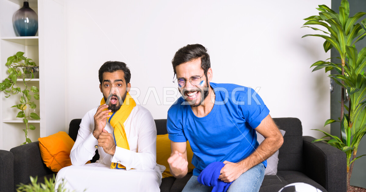 Two Saudi Arabian Gulf friends watching a Saudi league match, a young ...