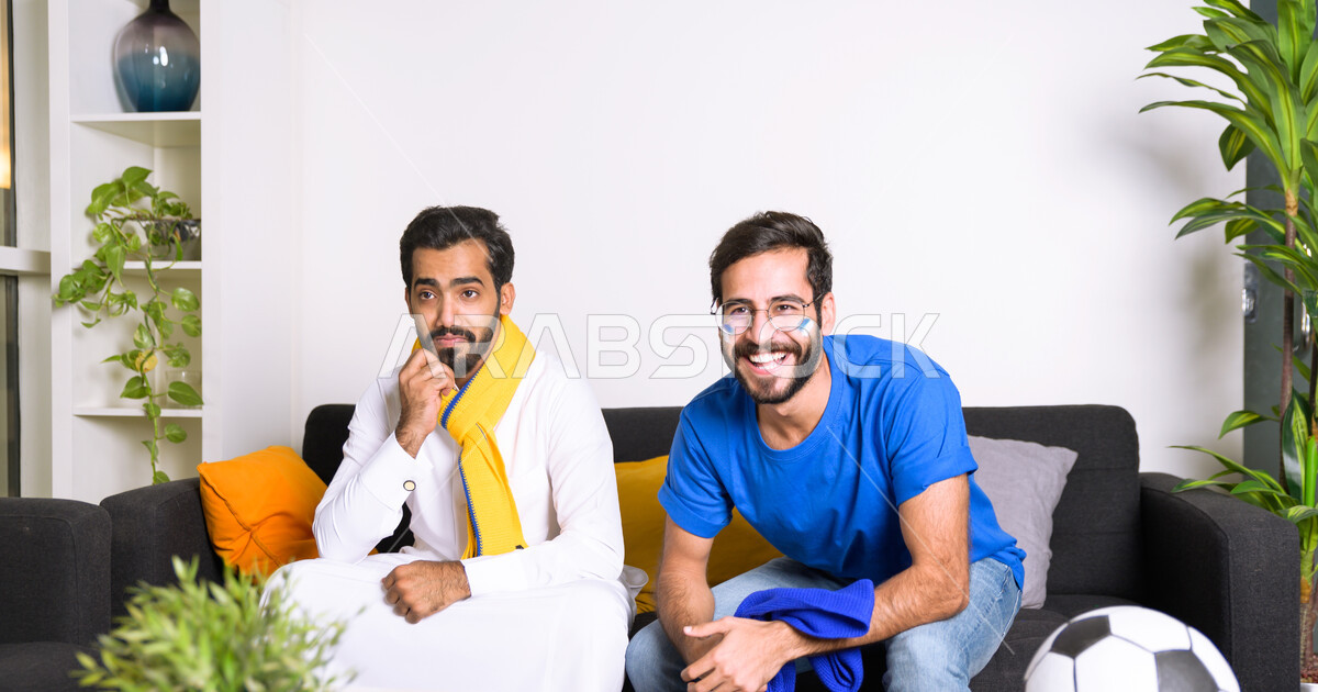 Two Saudi Arabian Gulf friends watching a Saudi league match, a young ...