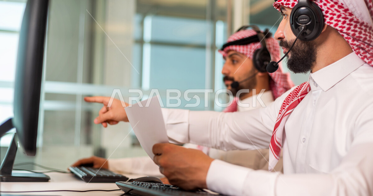 Two Saudi Arabian Gulf employees working in customer service in a ...