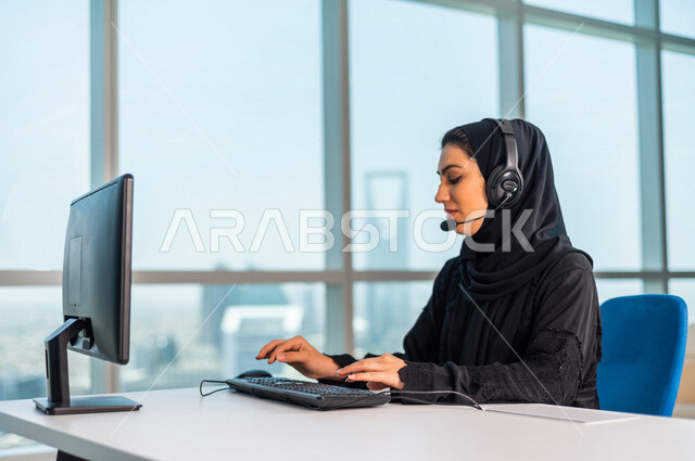 An Arab Saudi Arabian Gulf employee working in customer service wears a ...