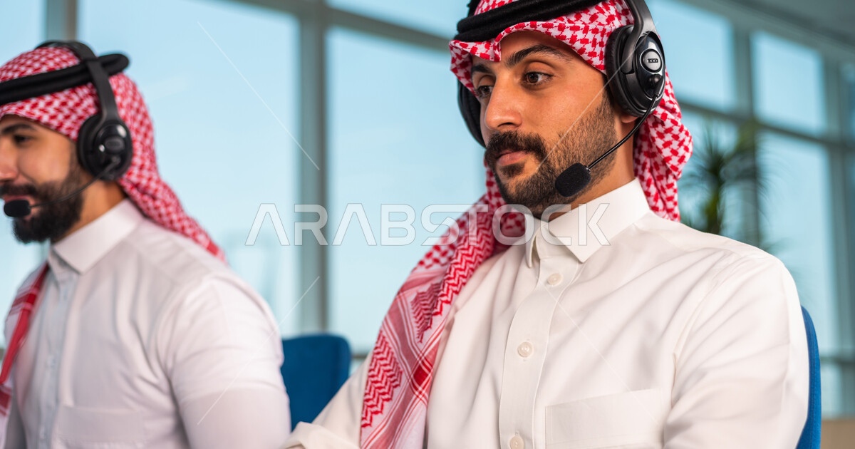 Two Saudi Arabian Gulf employees working in customer service in a ...