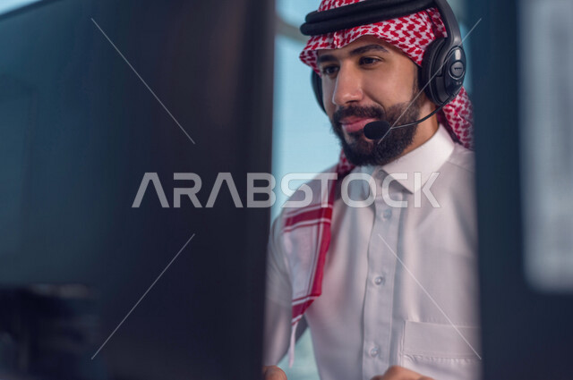 A smiling Saudi Arabian Gulf employee while talking to a customer in ...
