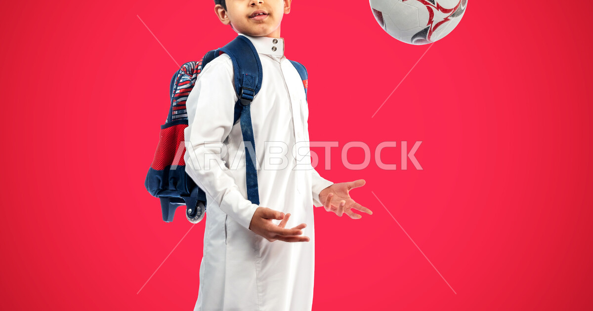 Portrait of a smiling Arab Gulf Saudi schoolboy, wearing a school ...