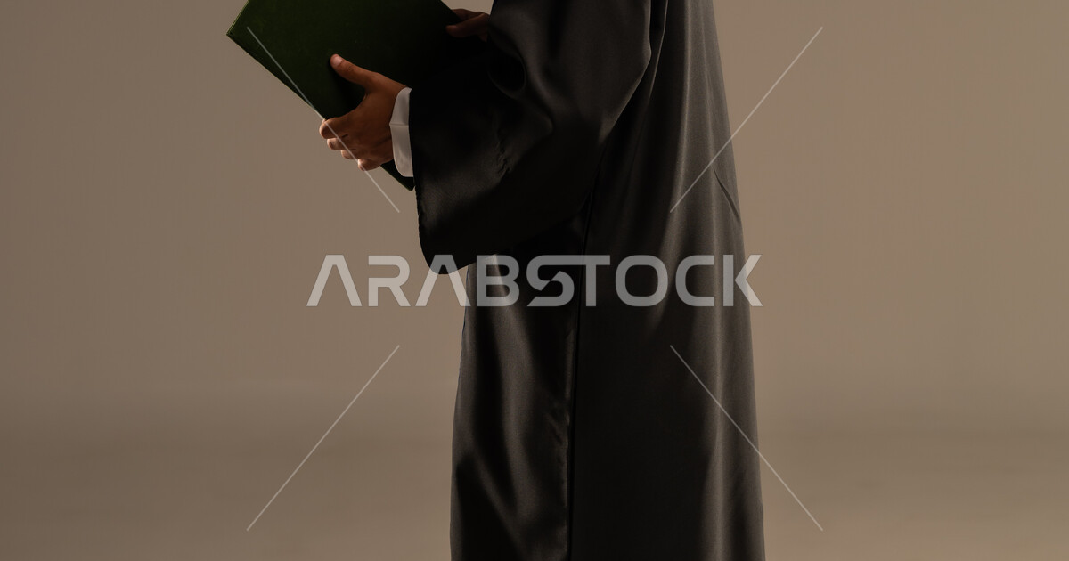 Gestures of pride and happiness, side portrait of a Saudi Arabian Gulf student wearing an abaya ...