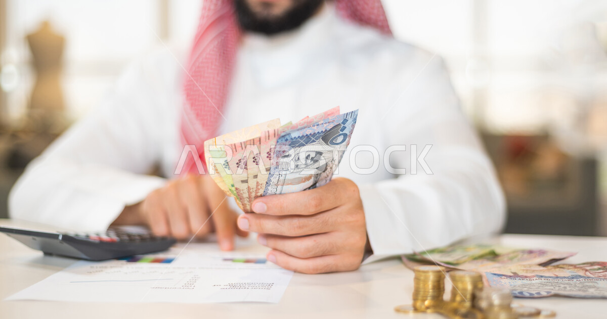 A blurry picture of a Saudi Arabian Gulf man, working on managing ...
